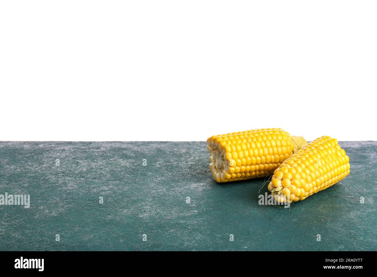 Cut fresh corn cobs on blue table against white background Stock Photo ...