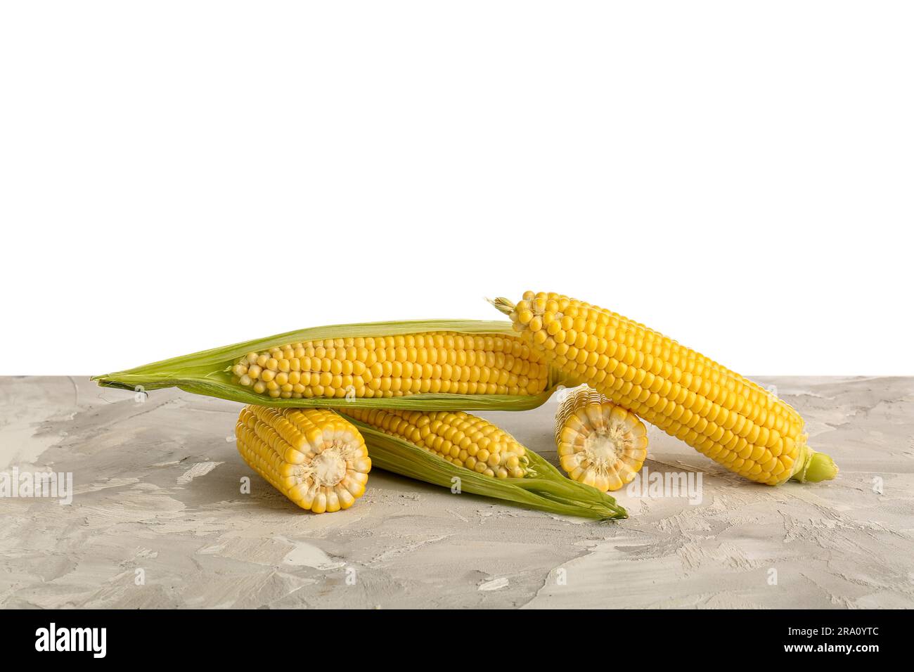 Fresh corn cobs on grey table against white background Stock Photo - Alamy