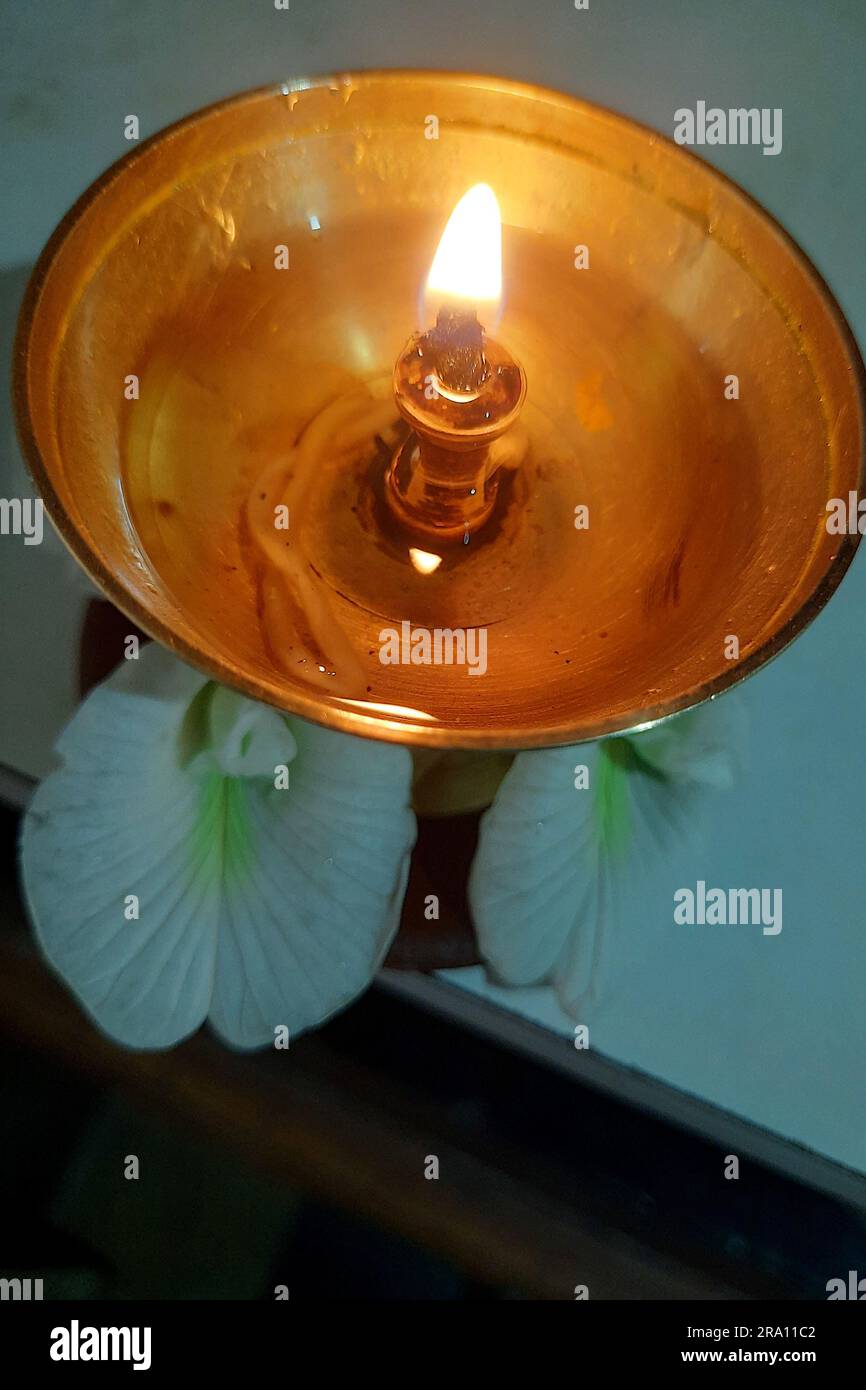 View of brass, oil lamp with burning cotton wick used during puja Stock ...