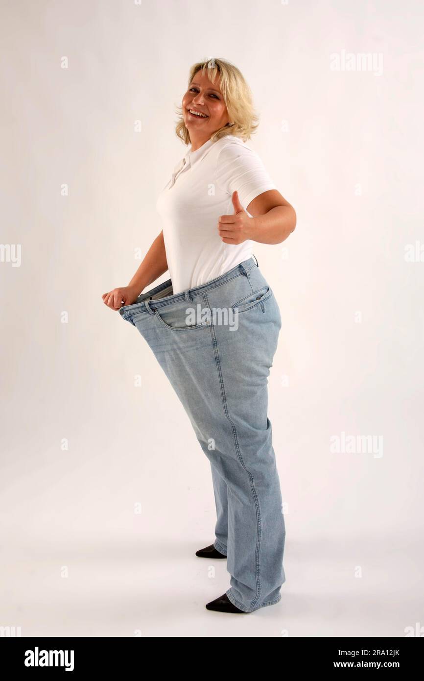Woman with much too wide trousers after weight reduction, diet, exempt ...