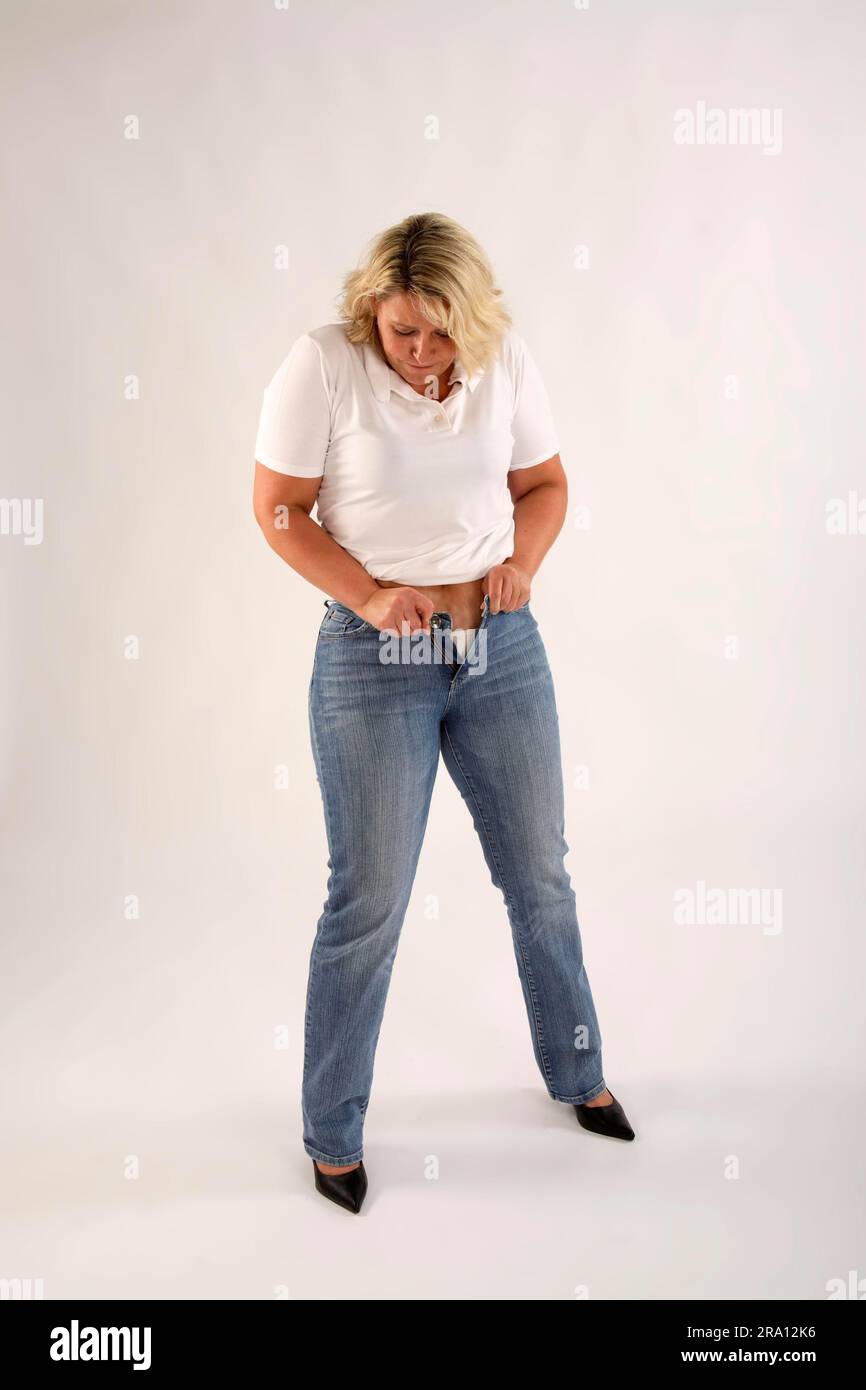 Woman tries to button jeans, too tight, too small, too tight trousers ...