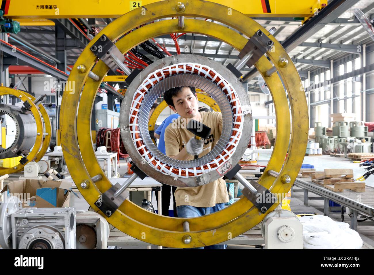 FUZHOU, CHINA - JUNE 17, 2023 - Workers wire a generator stator at a ...