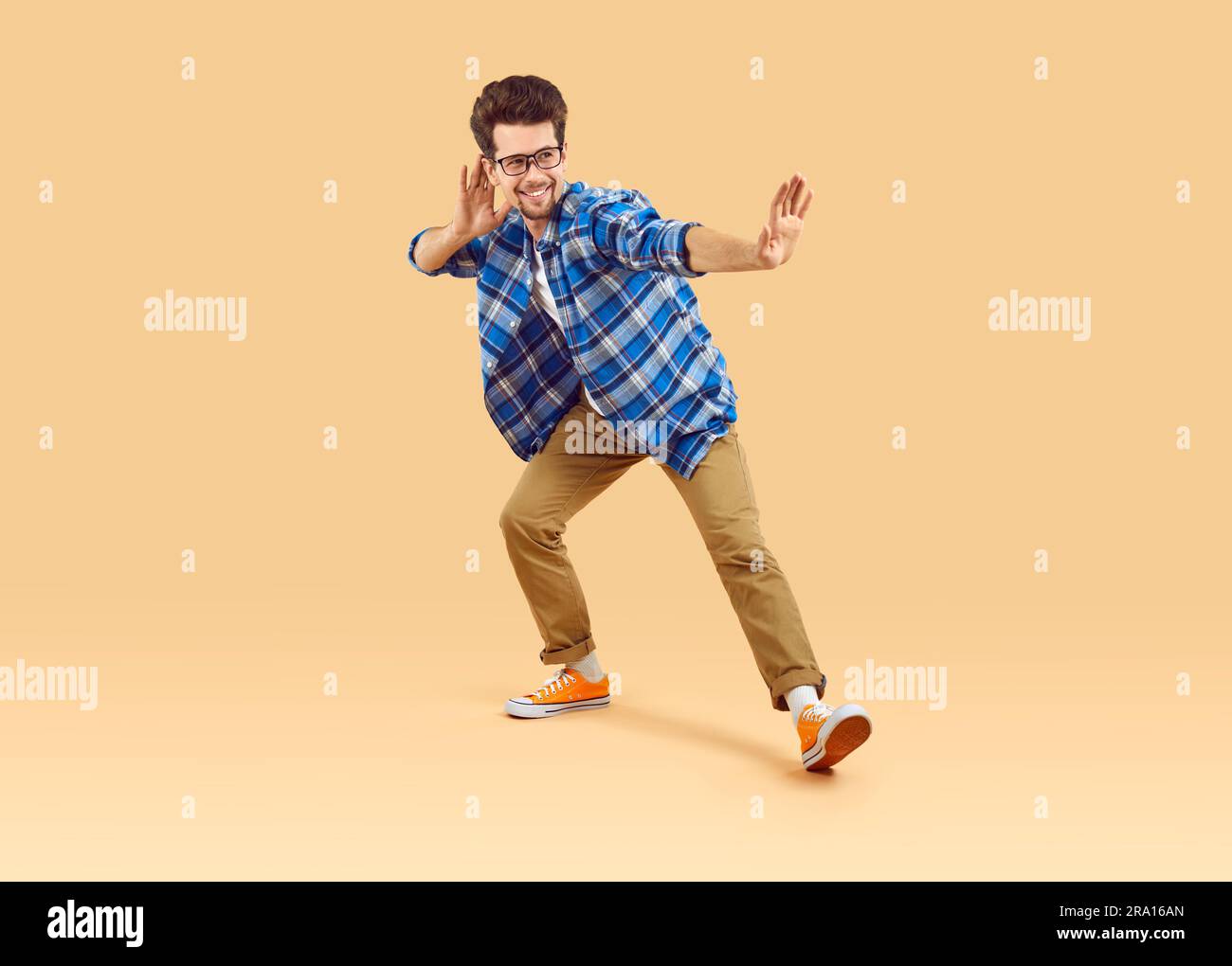 Happy, funny, joyful student in casual clothes and glasses dancing on a ...