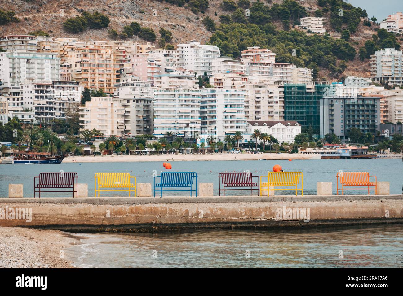 a small wharf with colorful metal chairs on the main beach of Sarandë ...