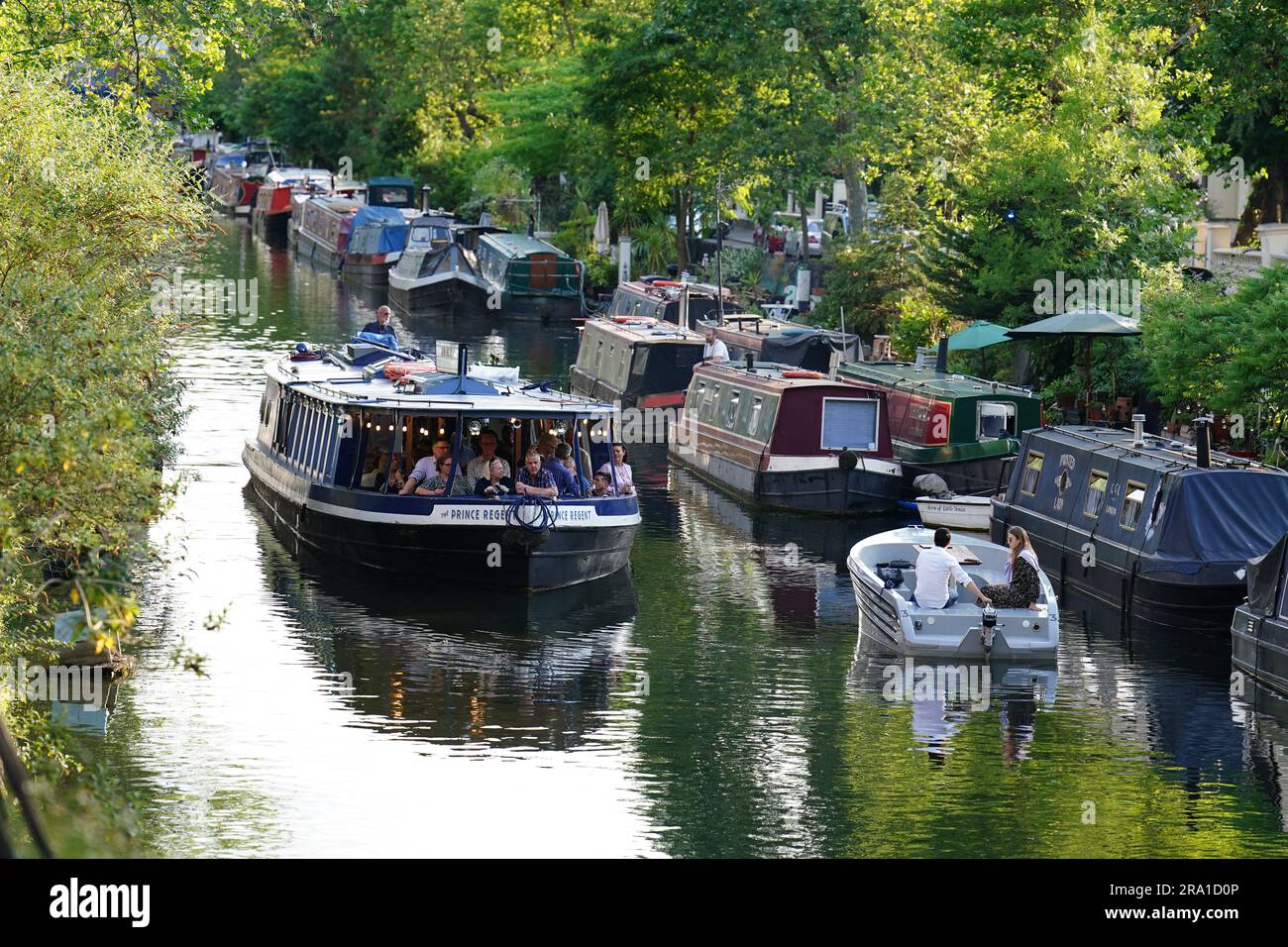 A tourist pleasure boat sails along the Regents Canal in Little Venice ...