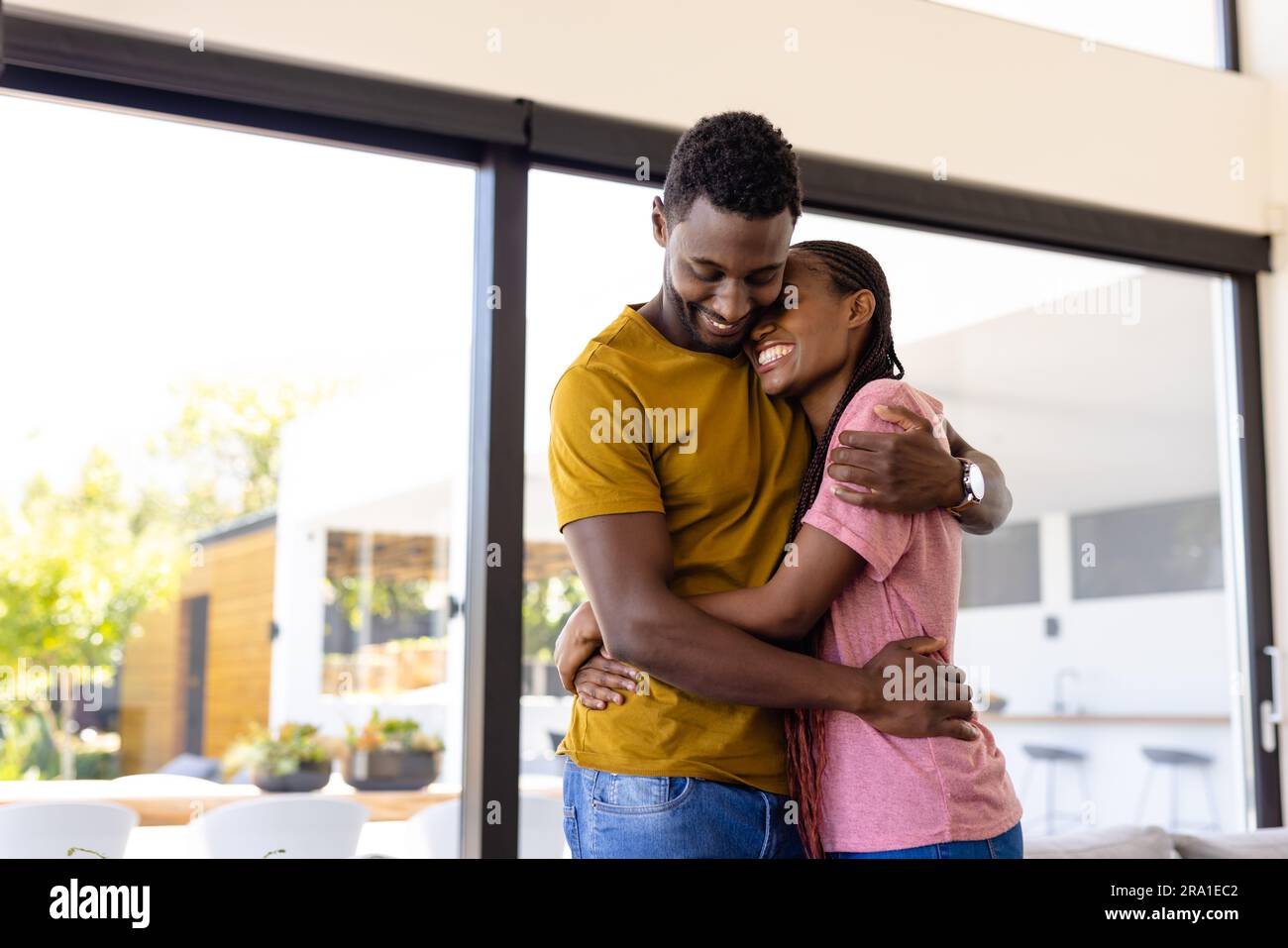 Happy african american couple hugging in living room Stock Photo - Alamy
