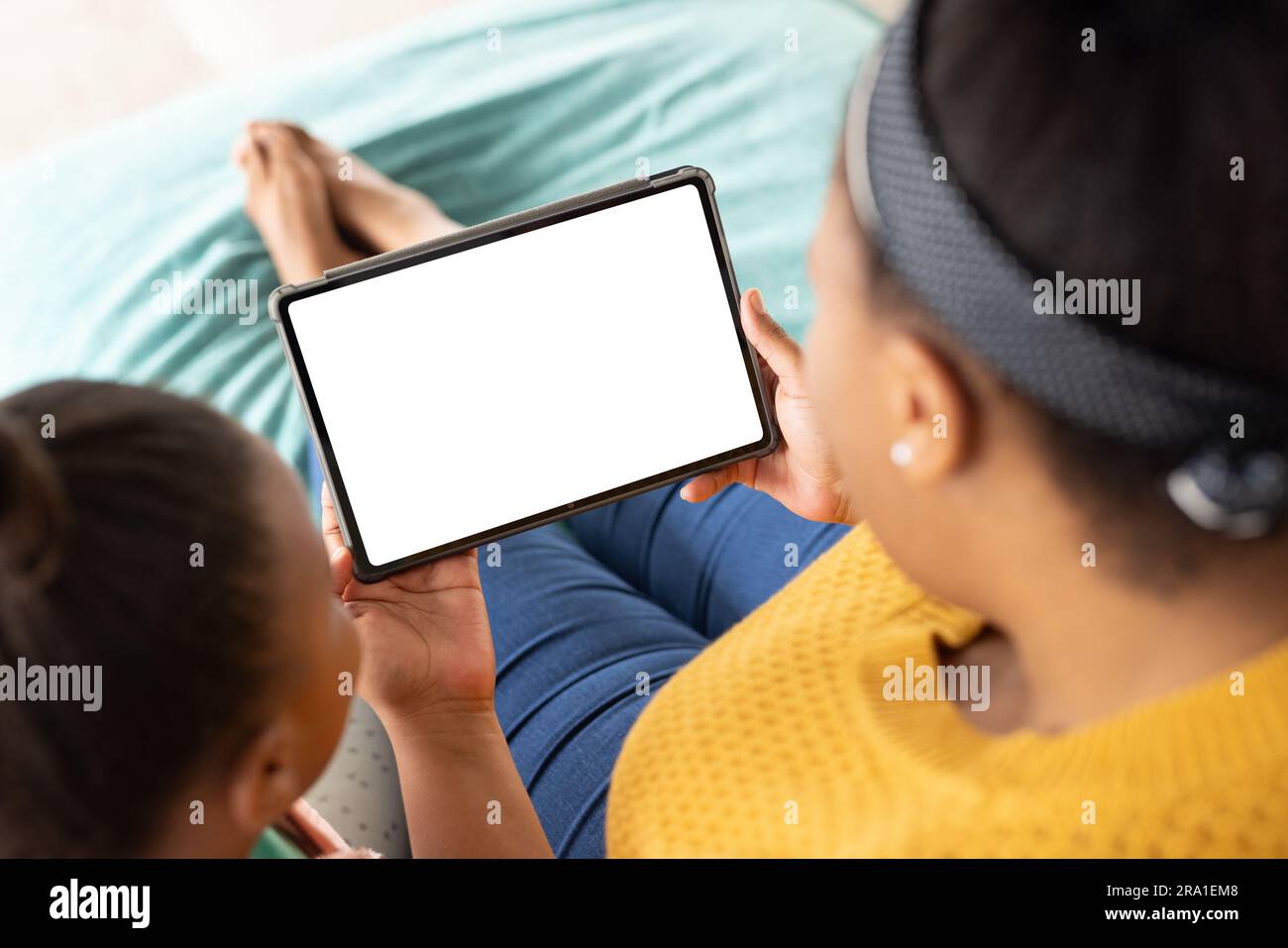 African american mother and daughter sitting on bed and using tablet with copy space Stock Photo ...