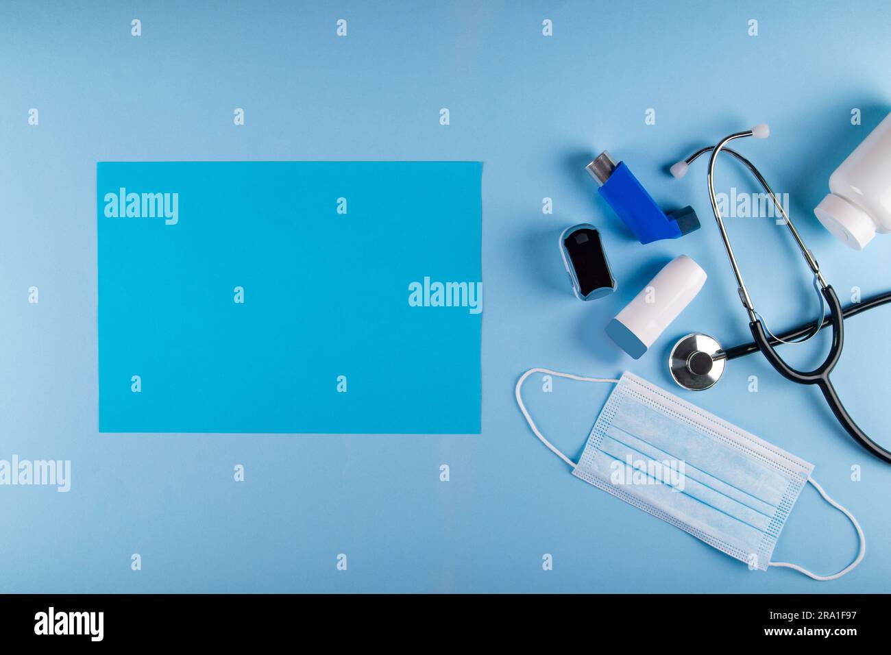 Top view of medical mask, stethoscope, oximeter, bottle of pills and ...