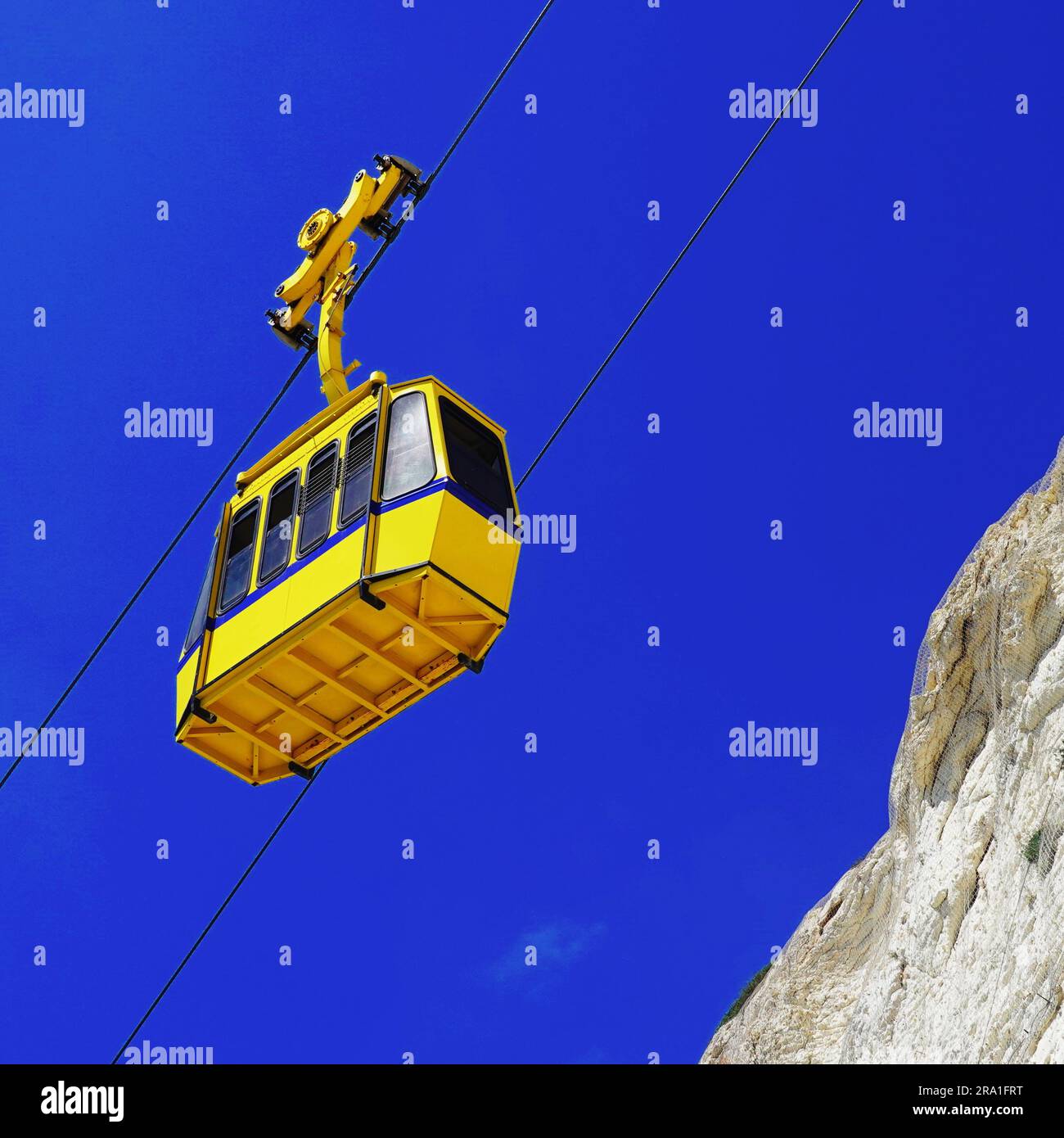Yellow Cableway Cabin against sky and chalk cliff. Rosh Hanikra ...