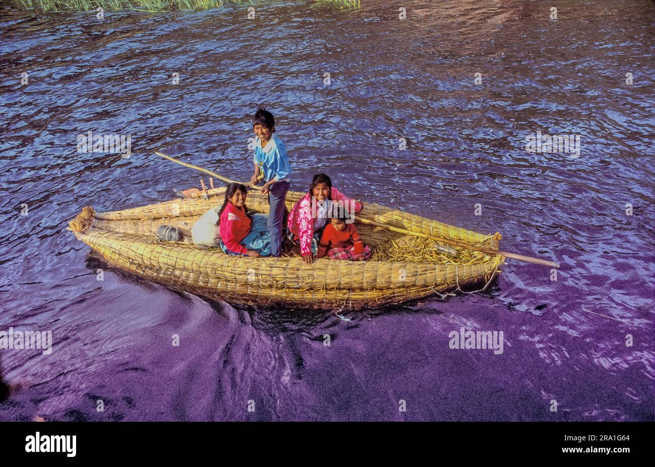 Peru, mother and children in a rowing boat made of papyrus, on the ...