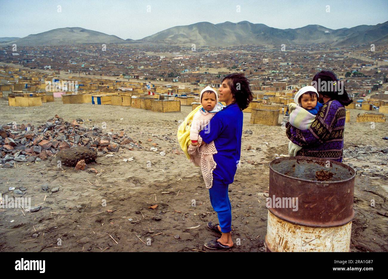Peru, Lima; Women and children in a large slum with houses made of reed ...