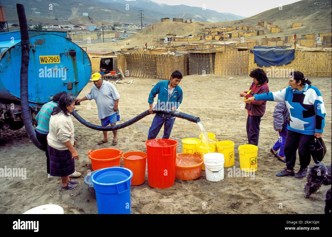 Peru, Lima; Water distribution by a tank truck in a slum. The dwellings ...