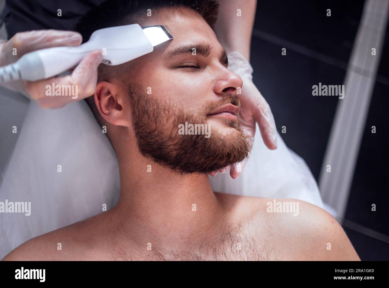 Beauty master makes ultrasonic facial peeling to her client. Young ...