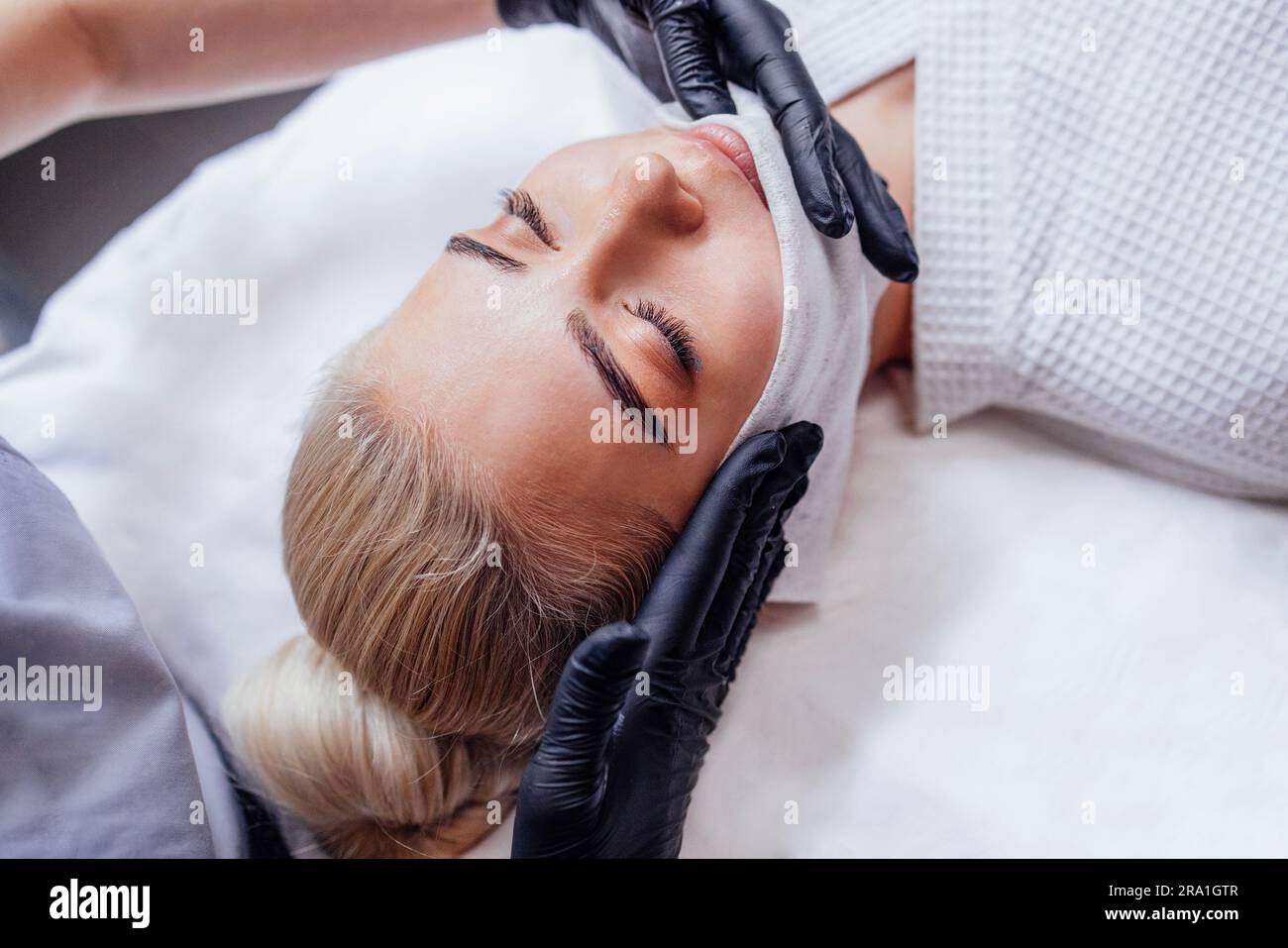 Close up of face of young blonde girl lying with her eyes closed during ...