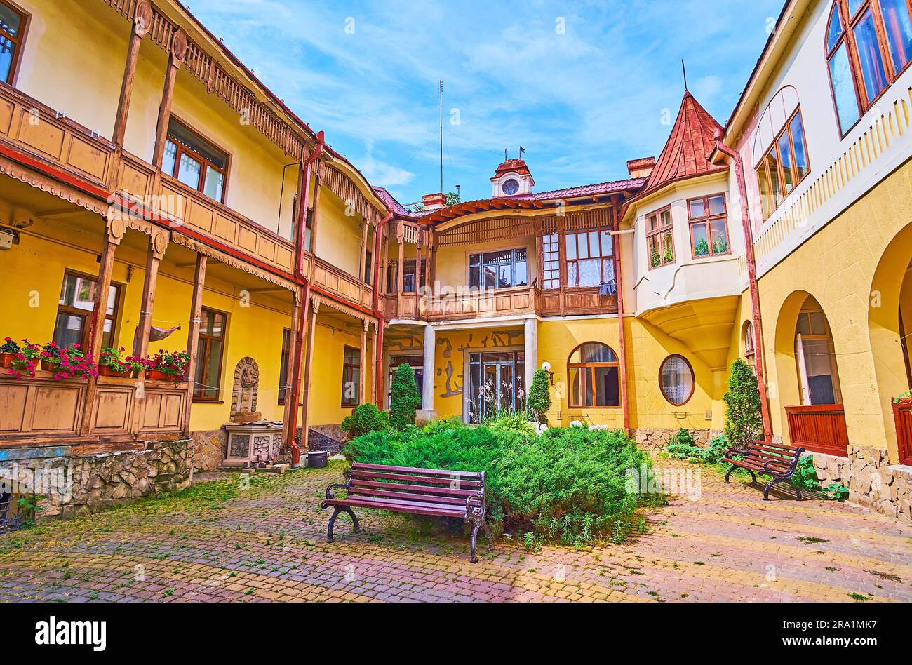 The old shabby courtyard, surrounded with yellow buildings, decorated ...