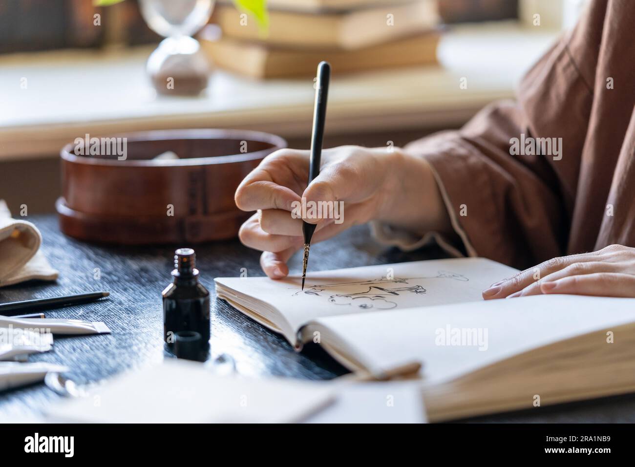 Artist using pen drawing in sketchbook with black ink Stock Photo - Alamy