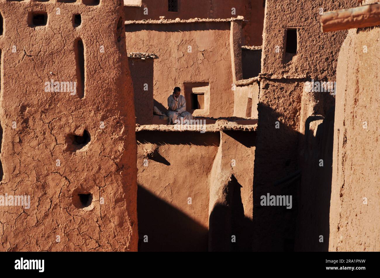 African man Talking on cellphone amongst clay buildings in Morocco ...