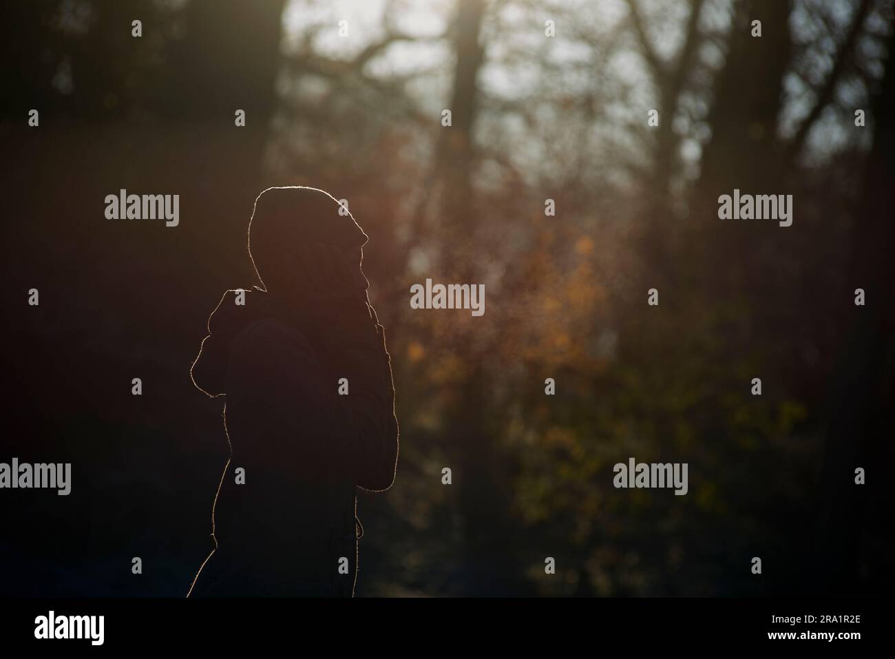 Side profile of Asian woman enjoying the cold weather blowing mist ...