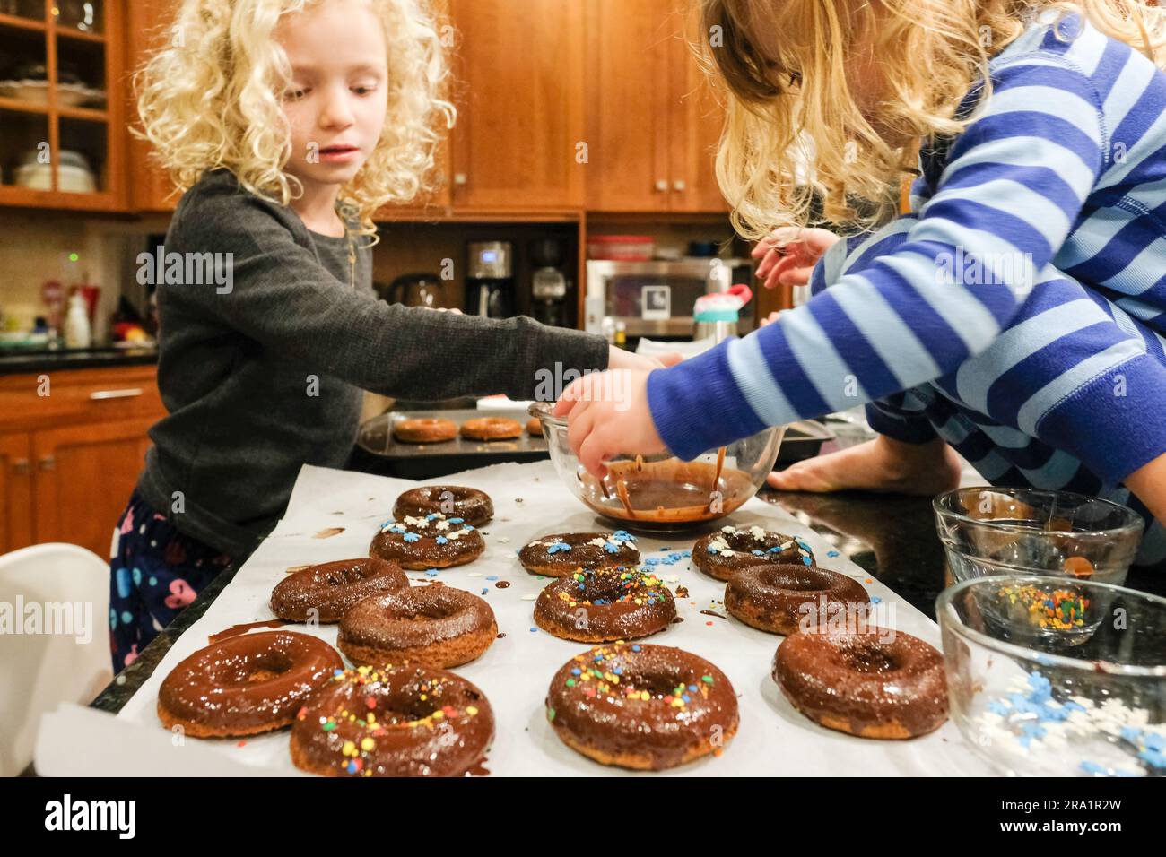 close up side view of two children making donuts at kitchen counter Stock Photo - Alamy