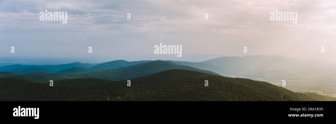 A panoramic view of a wide mountain range in Virginia with sun rays ...