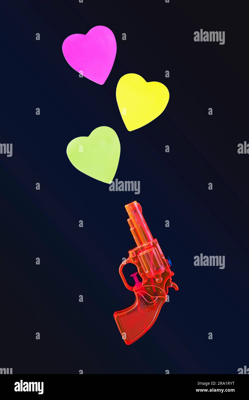 Toy gun shoots symbolic hearts as a declaration of love Stock Photo - Alamy
