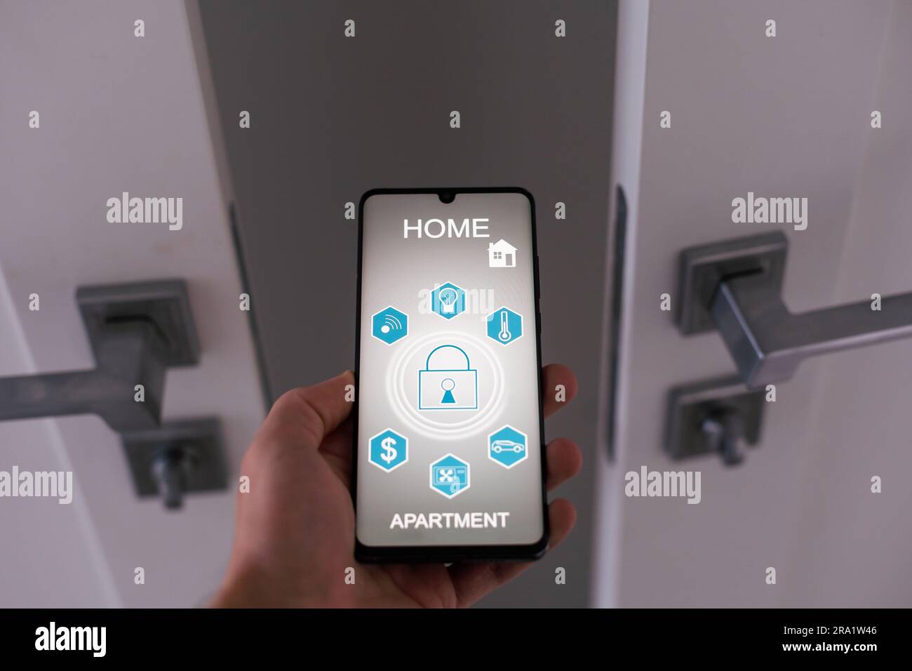 hands holding smart phone with app smart home on blurred living room as ...