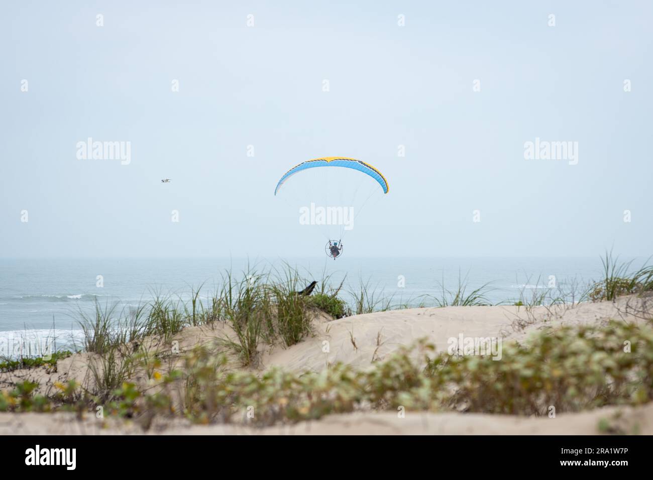 Powered paragliding over ocean waves Stock Photo - Alamy