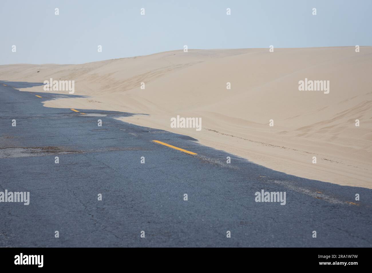 Sand dunes spilling over into road Stock Photo - Alamy