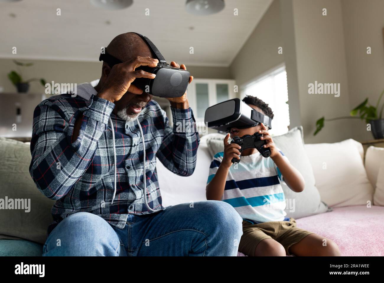 Happy african american grandfather and grandson playing video games and ...