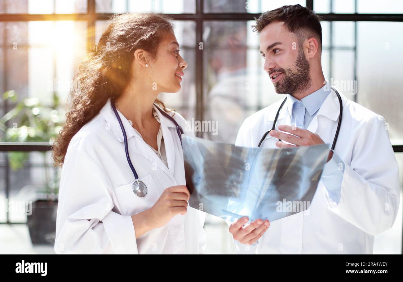 Two busy doctors working with papers and xray images Stock Photo - Alamy