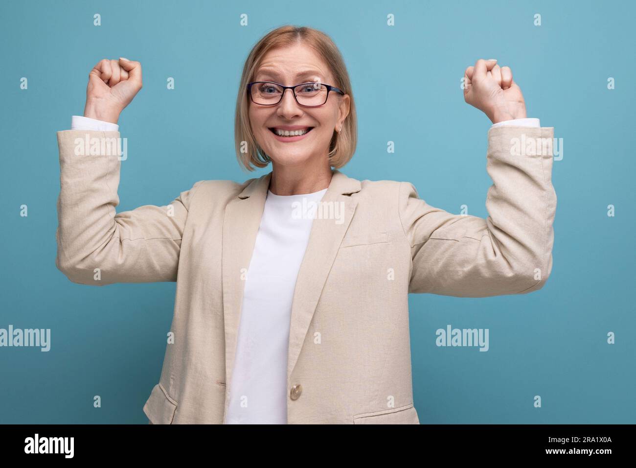 happy 50s mature woman in a stylish jacket won a victory on a plain ...