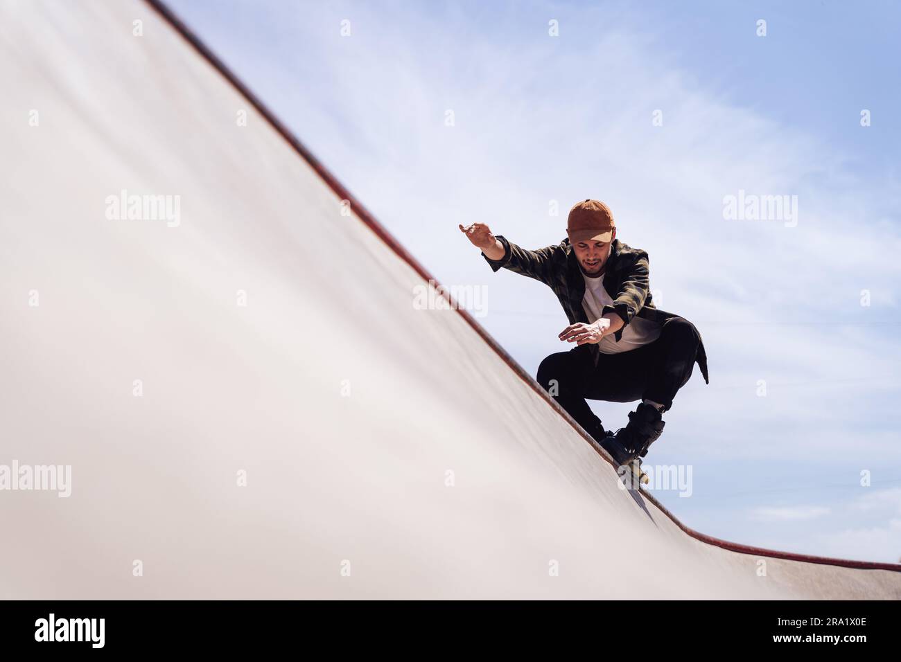 aggressive roller skater performing a trick on a railing in skatepark ...