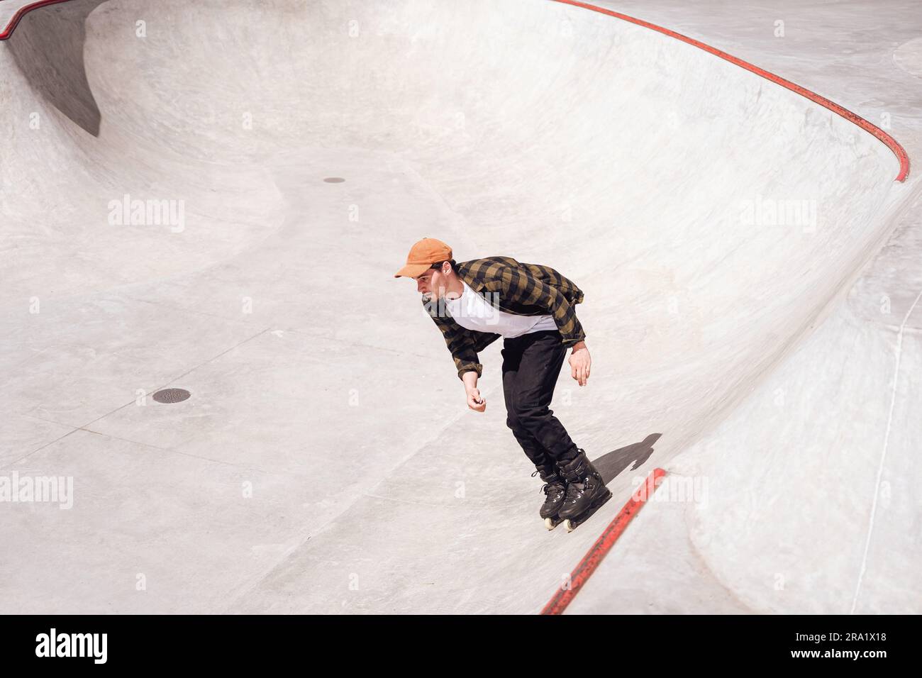 aggressive roller skater performing a trick on a railing in skatepark ...
