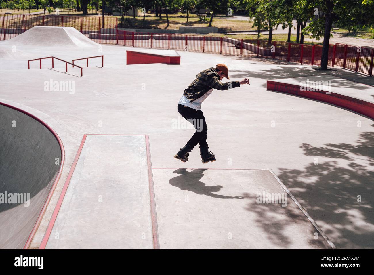 aggressive roller skater performing a trick in skatepark Stock Photo ...