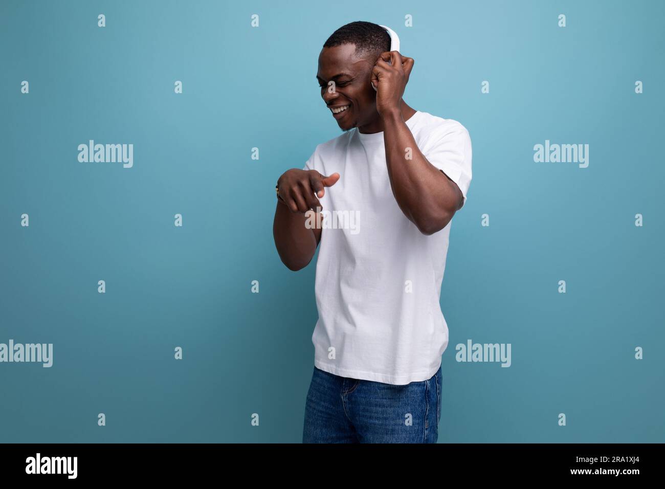 well-groomed handsome young african guy dancing to music in headphones ...