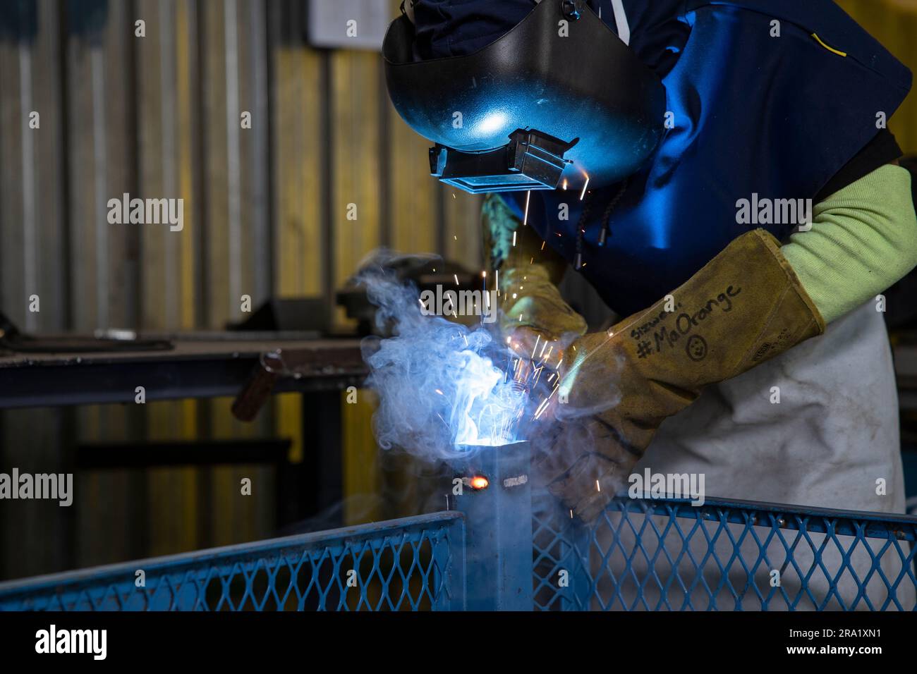 An experienced welder working alone in a metal factory, completing a ...