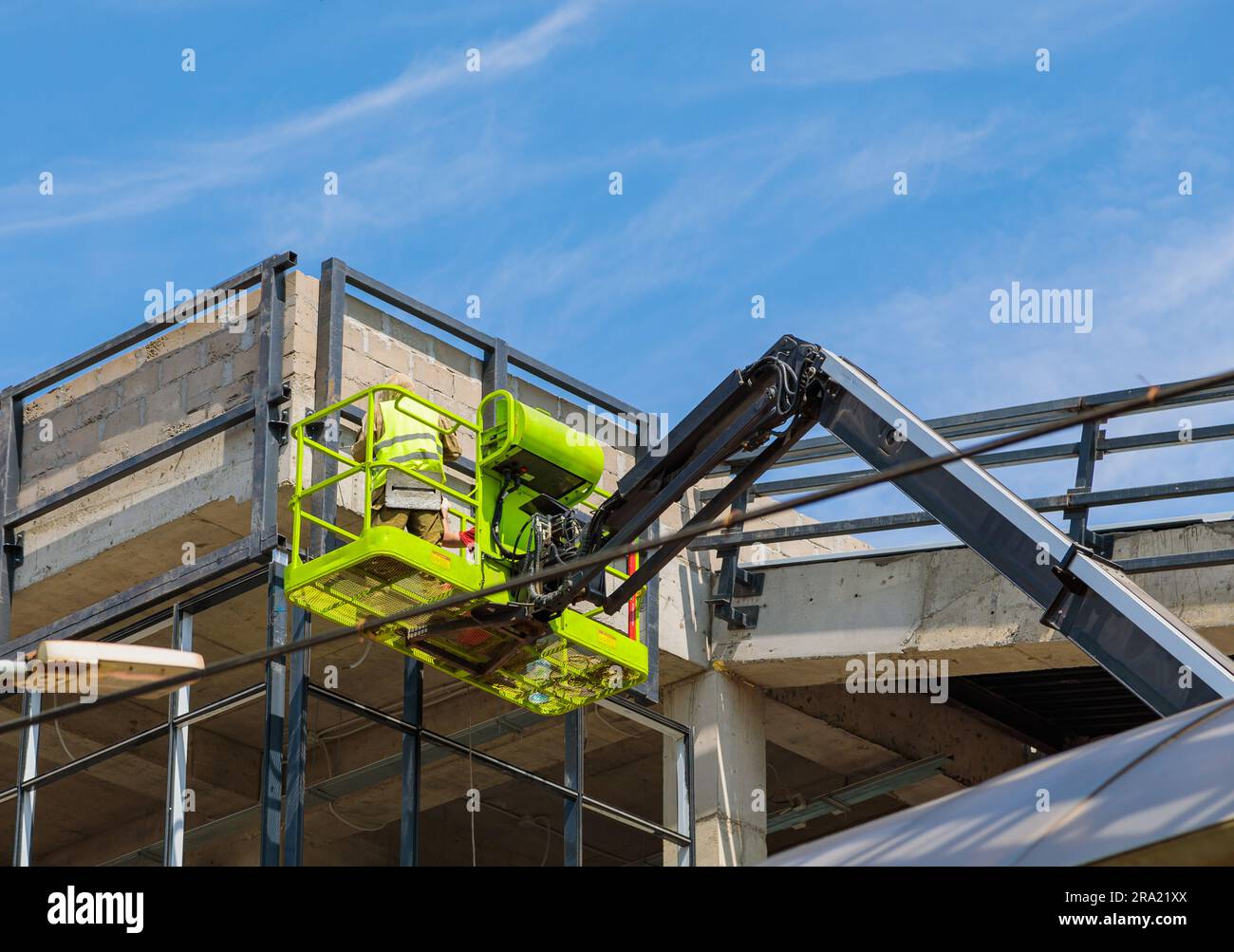 Man - a builder works at the site of the crane at height. Construction ...