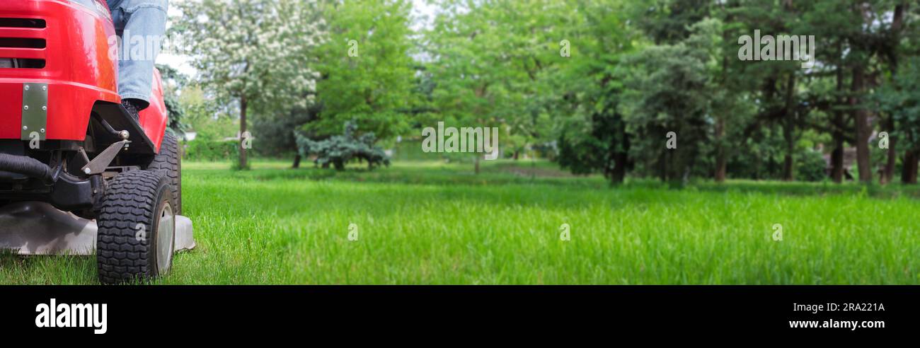 Lawnmower in action on green turf. Banner with text area, copyspace ...