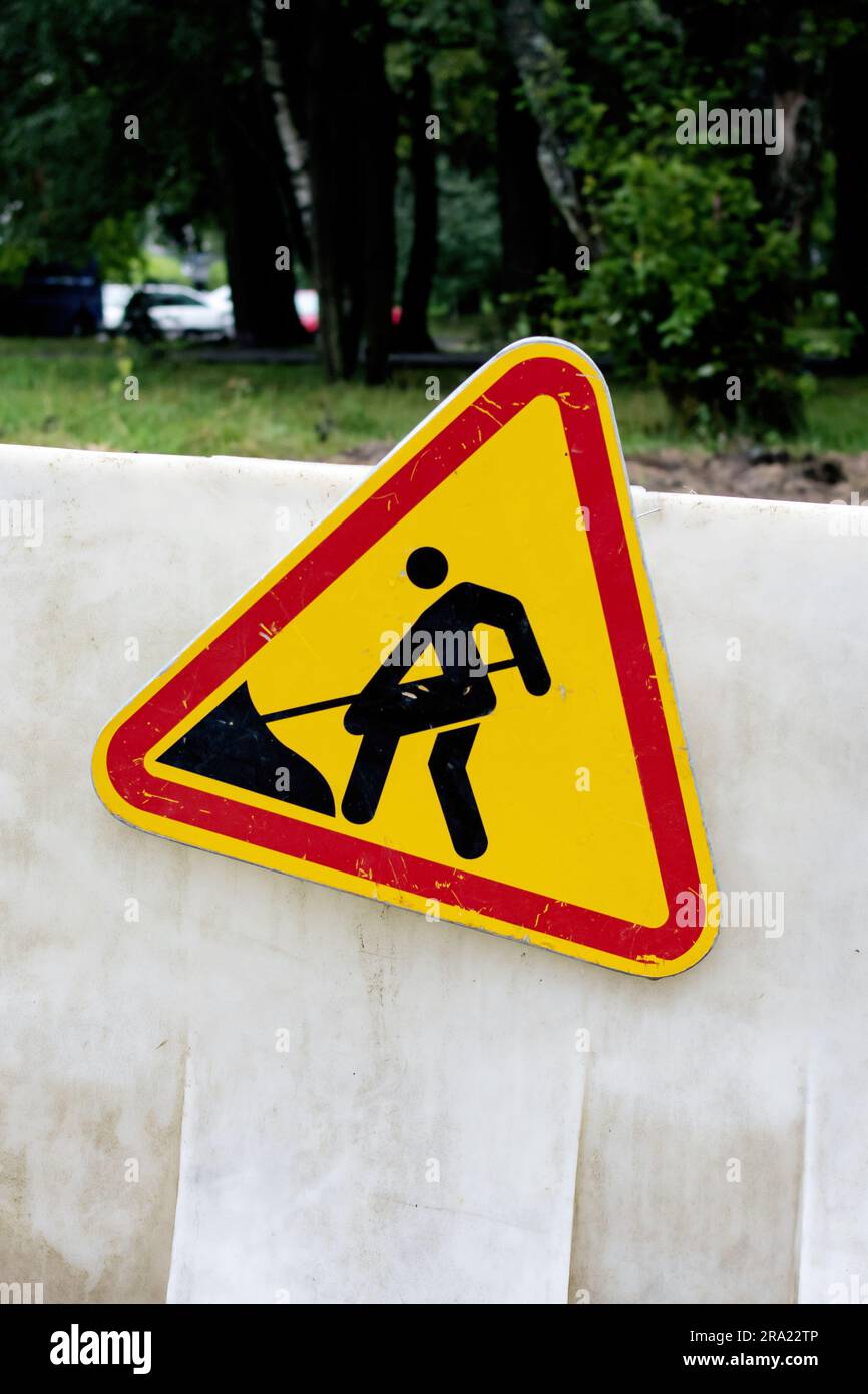 Construction work sign on the fence on grass Stock Photo - Alamy