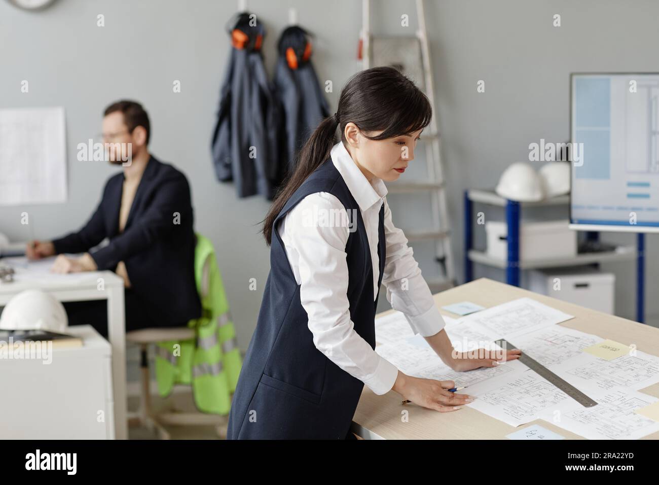 Side view portrait of Asian woman as female engineer drawing blueprints ...