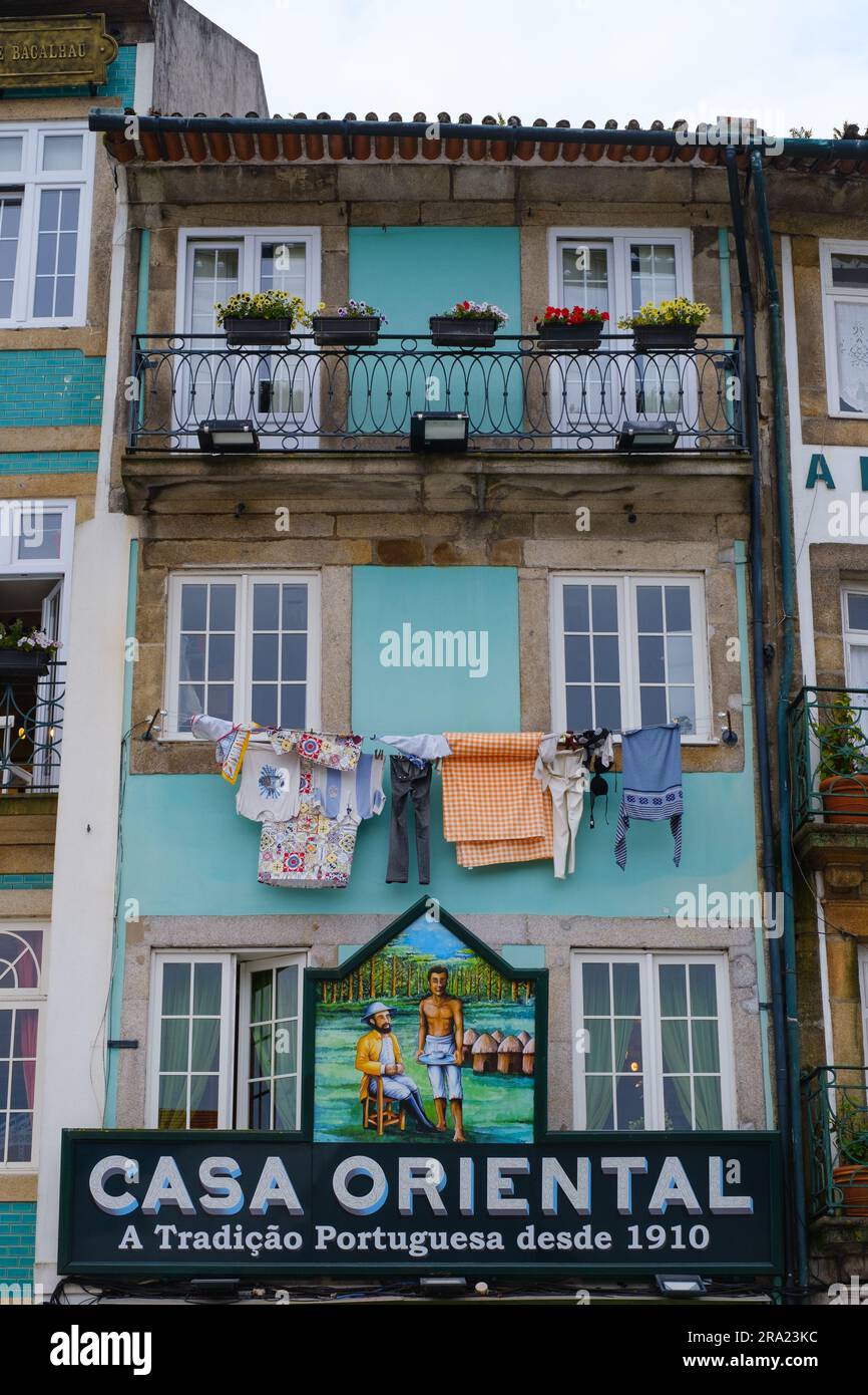 Laundry hanging from a colourful traditional building store in Porto ...