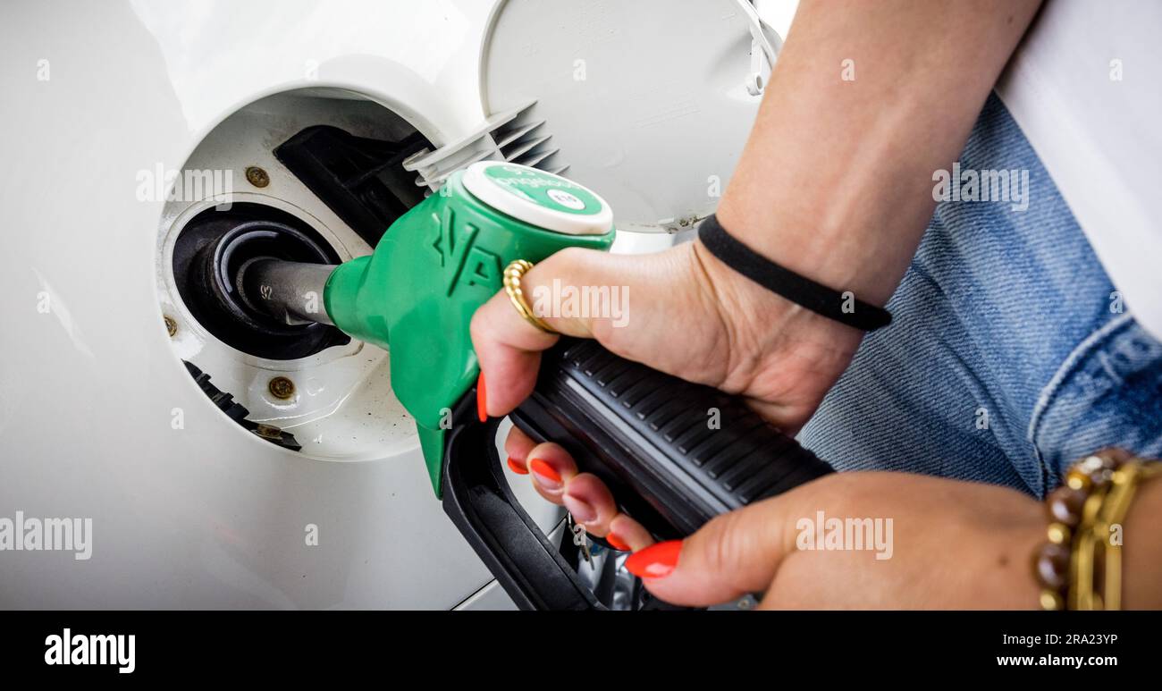 HELMOND - A woman fills up her car at a Tango gas station in Helmond ...