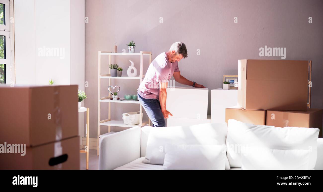 Lifting Heavy Furniture With Back Pain. Man At Home Stock Photo - Alamy