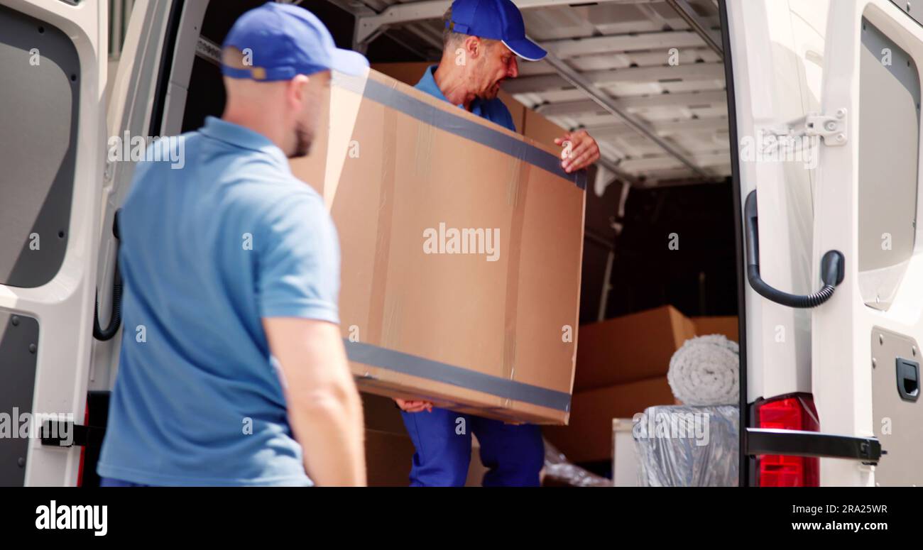 Male Movers In Uniform Loading Delivery Truck Stock Photo - Alamy