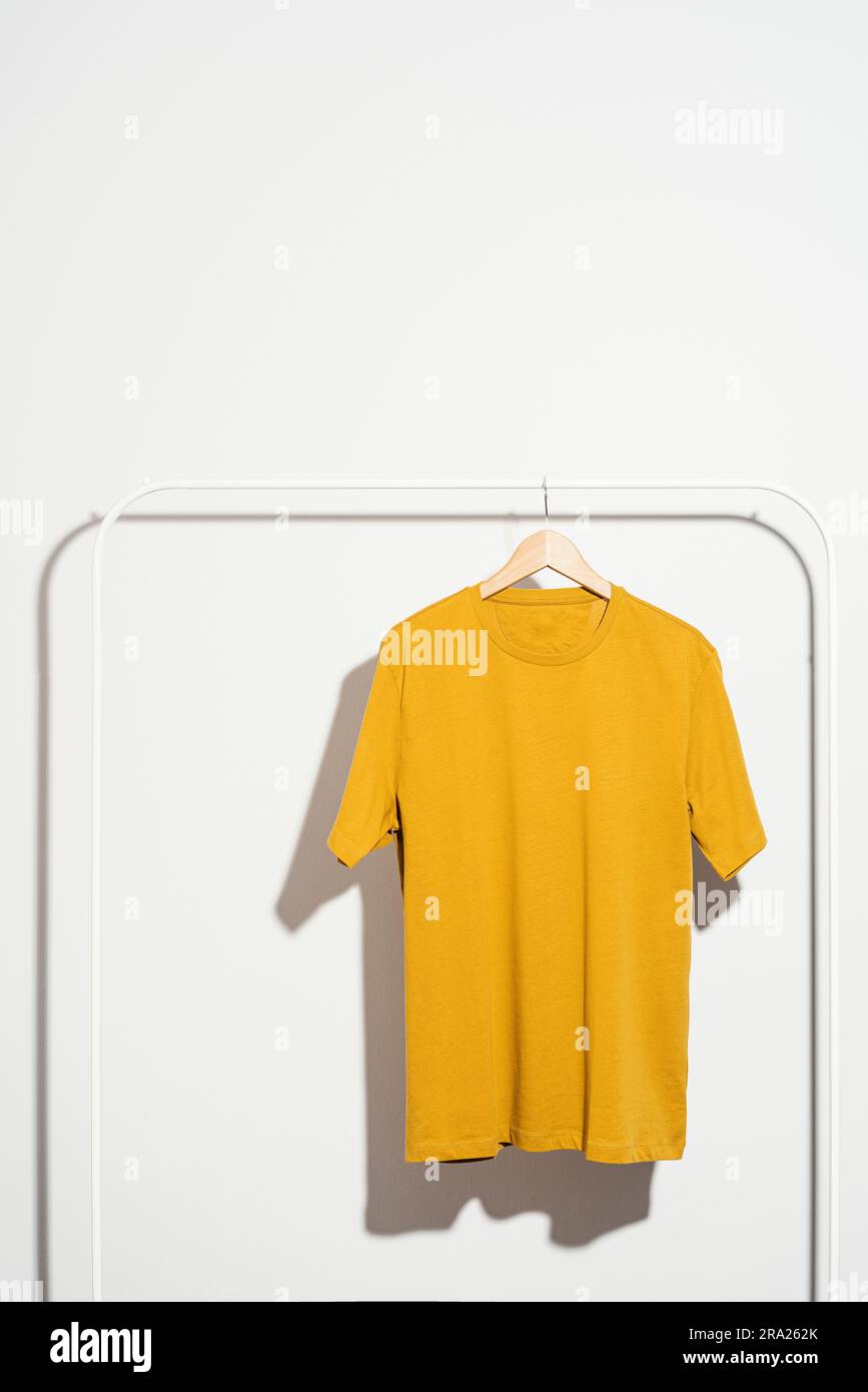 Blank yellow t-shirt mockup, template on wooden hanger displayed on ...