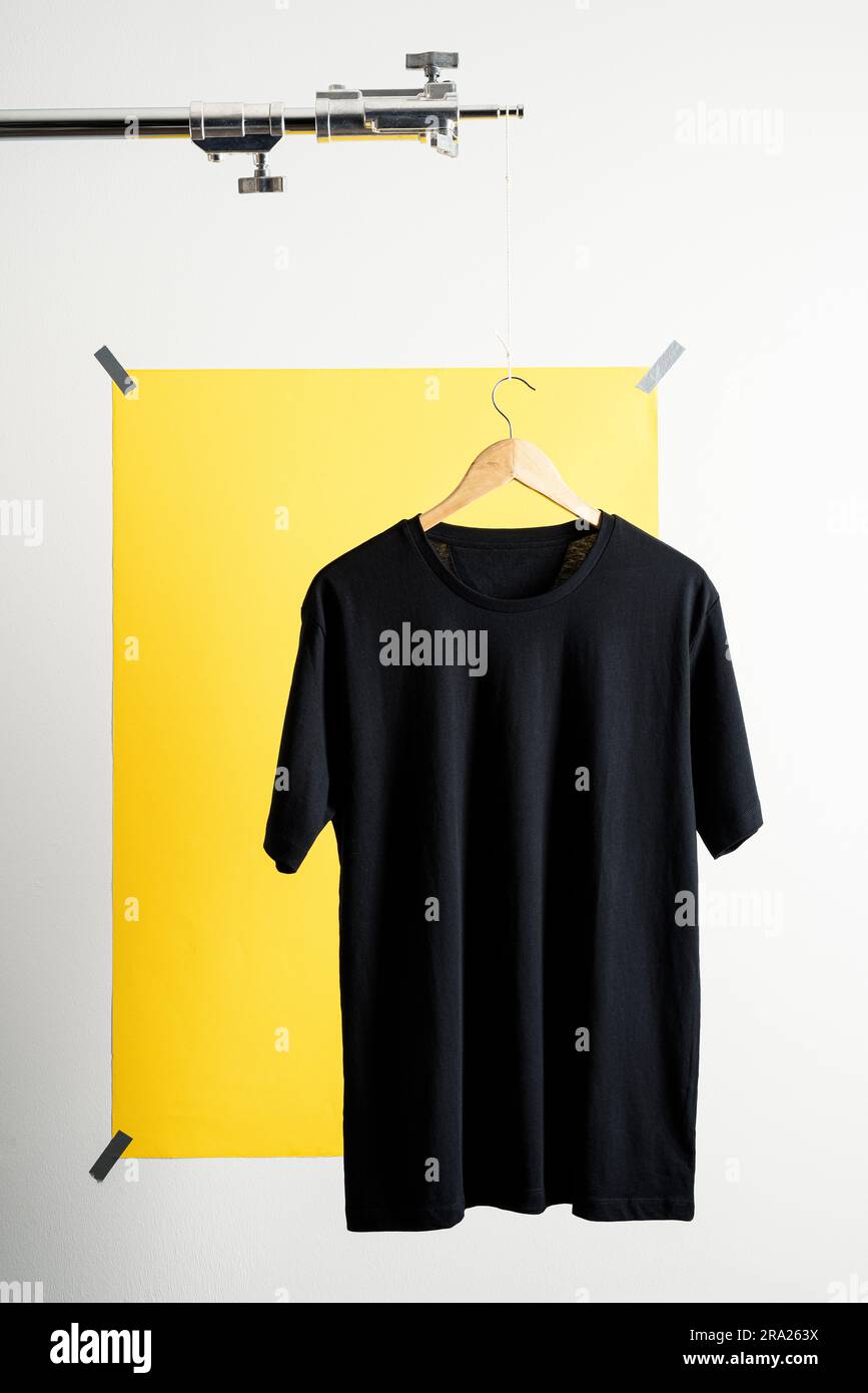 Blank black t-shirt mockup, template on wooden hanger, hanging from ...