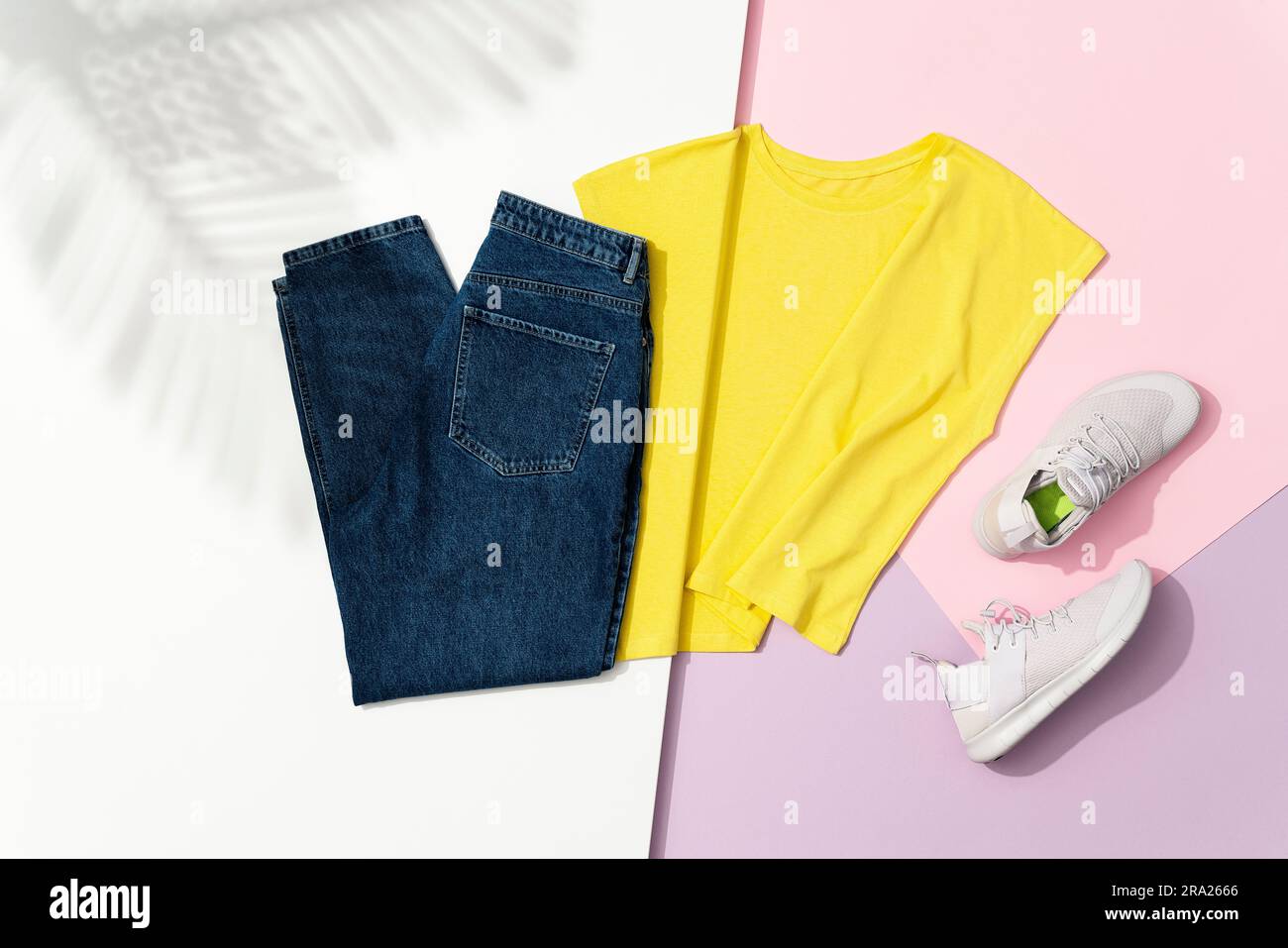 Yellow t-shirt, blue jeans and white sneakers on pink and white ...