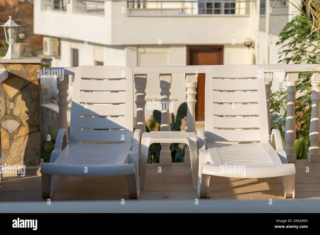 Two plastic sun loungers located on the balcony of a country house ...