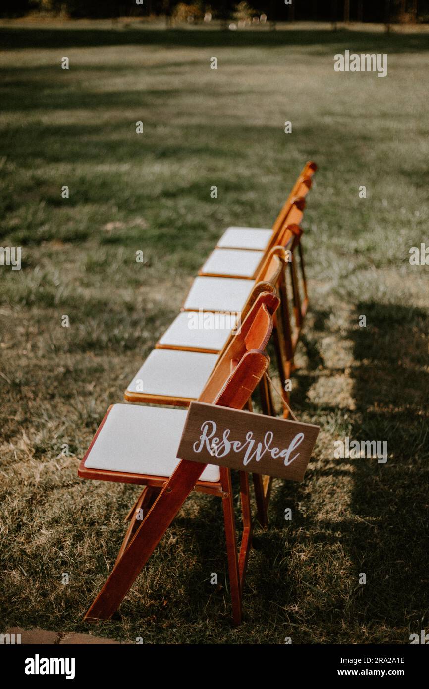 An Outdoor wedding pew with reserved seating sign Stock Photo - Alamy