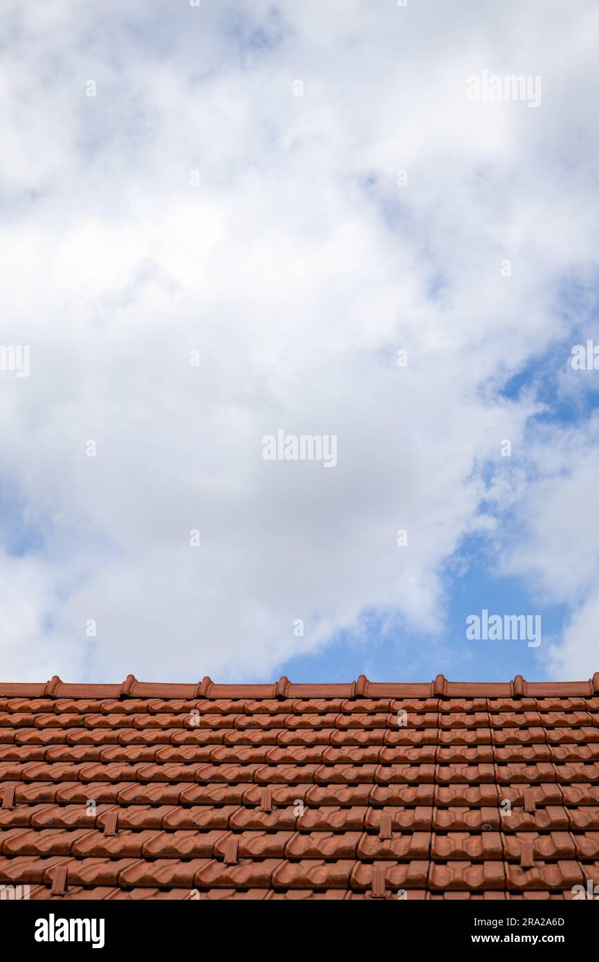 Red roof top and blue sky with clouds Stock Photo - Alamy
